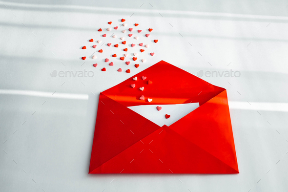 Opened red envelope and many felt hearts on white background with place ...