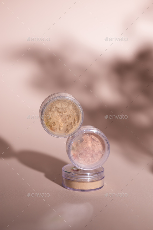 Mineral powder for skin tone color in small containers on pale rose ...