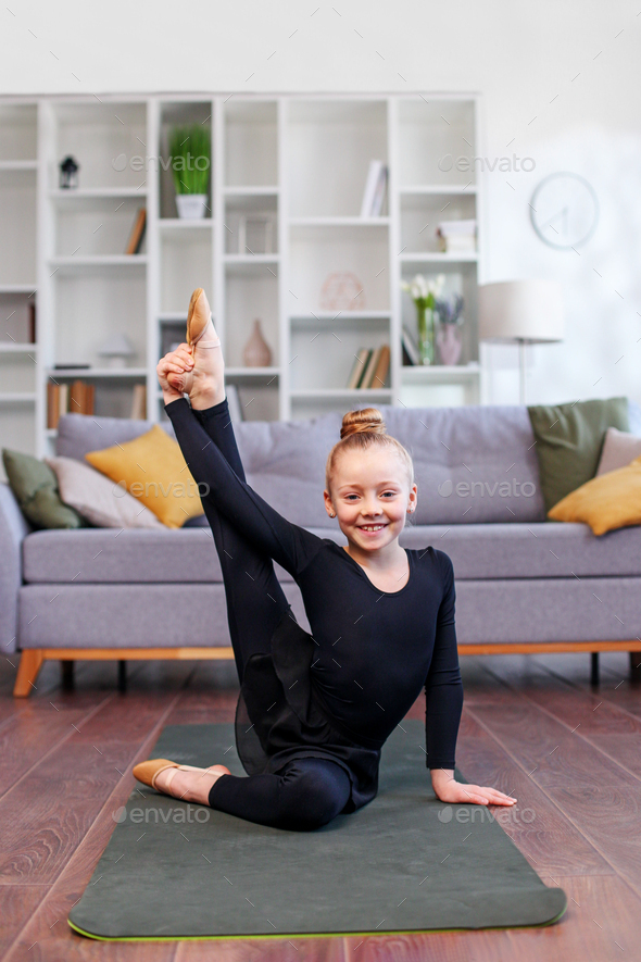 Little girl practicing stretching in room. Physical exercises for ...