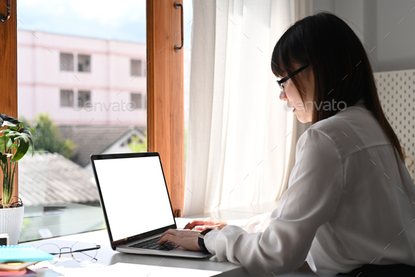 Concentrated female employee looking at laptop screen, working in ...