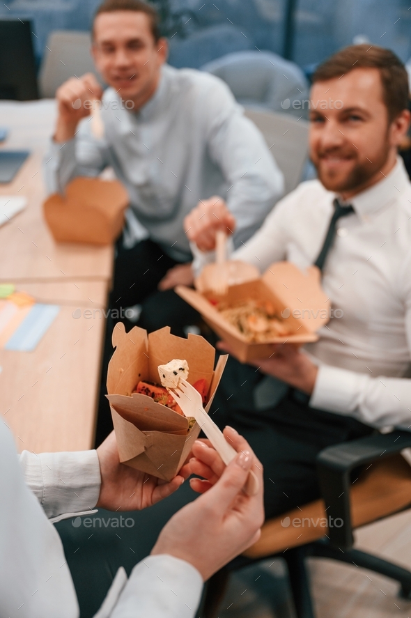 Group of coworkers are eating food from eco boxes in the office ...