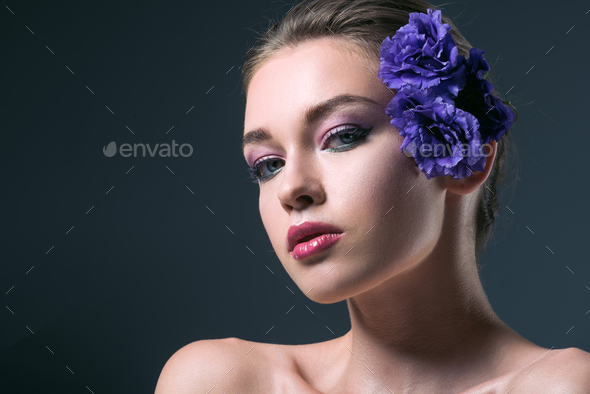 close-up portrait of seductive young woman with eustoma flowers behind ...