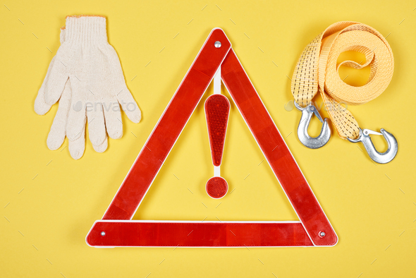 top view of warning triangle road sign, gloves and car tow rope ...