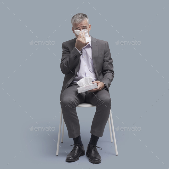 Patient with cold and flu sitting on a chair Stock Photo by stokkete