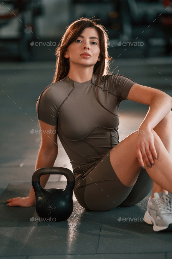Posing with dumbbell. Beautiful woman with sport body type is in the ...