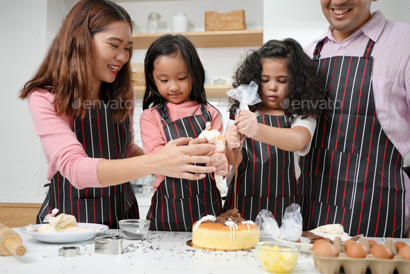 Child making cake with family, Family having fun together in kitchen ...