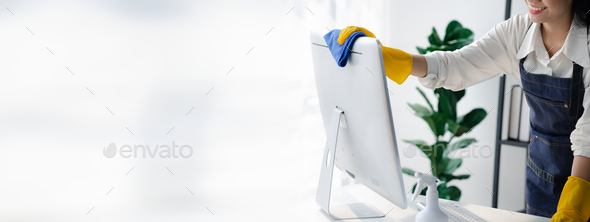Person cleaning room, cleaning worker is using cloth to wipe computer ...