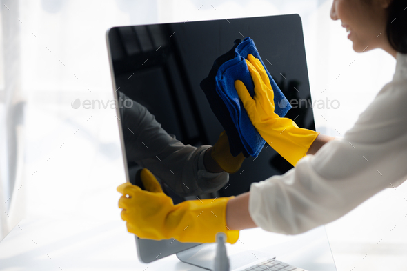 Person cleaning room, cleaning worker is using cloth to wipe computer ...