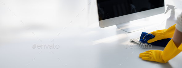 Person cleaning room, cleaning worker is using cloth to wipe computer ...