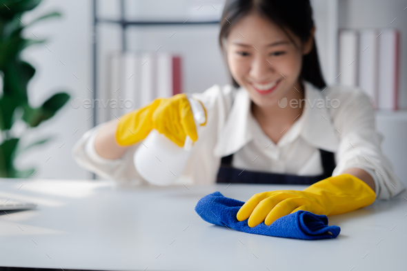 Person cleaning the room, cleaning staff is using cloth and spraying ...
