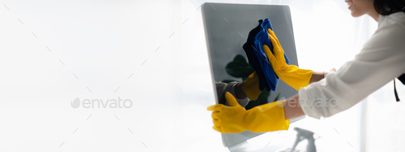 Person cleaning room, cleaning worker is using cloth to wipe computer ...