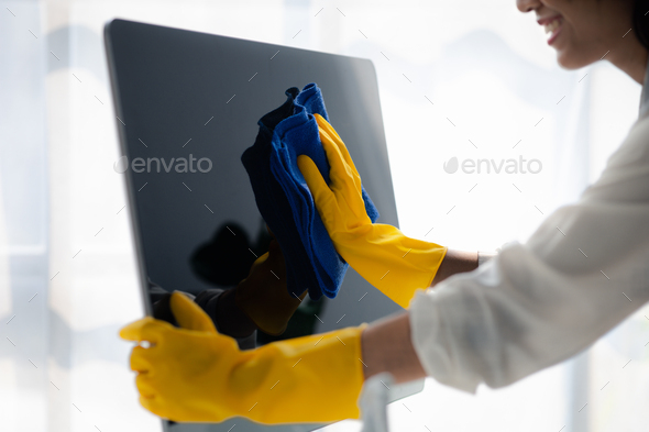Person cleaning room, cleaning worker is using cloth to wipe computer ...