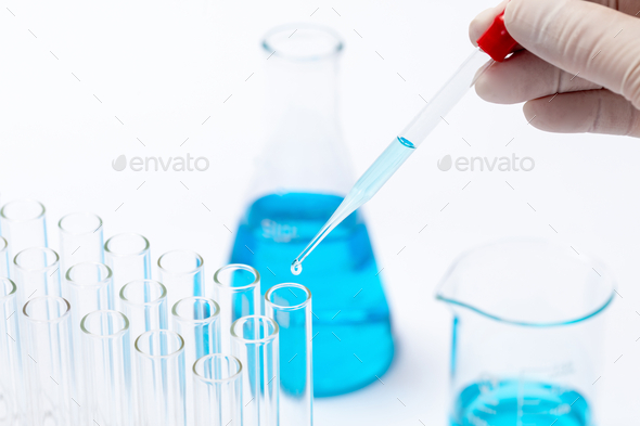 Closeup of a scientist experimenting with blue toxic substances in a ...