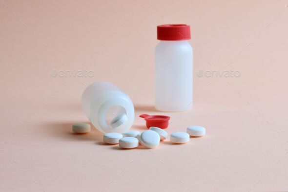 Closeup shot of two bottles of medical tablets, one closed and one ...