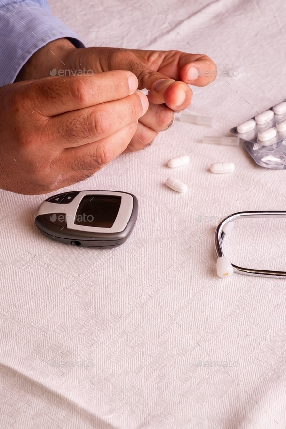 shot of a male hand collecting blood sample for hgt test with tablets ...