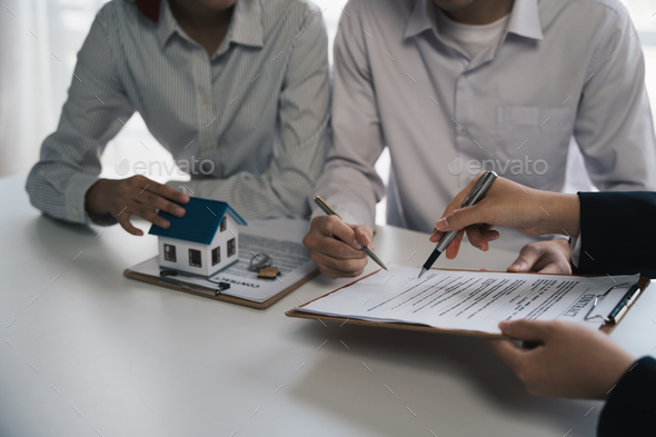real estate agent or salesman holds a house model to describe the ...