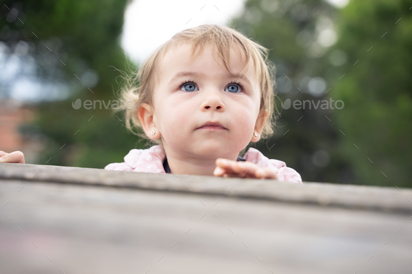 Low angle of a curious and cute little girl outdoors Stock Photo by ...