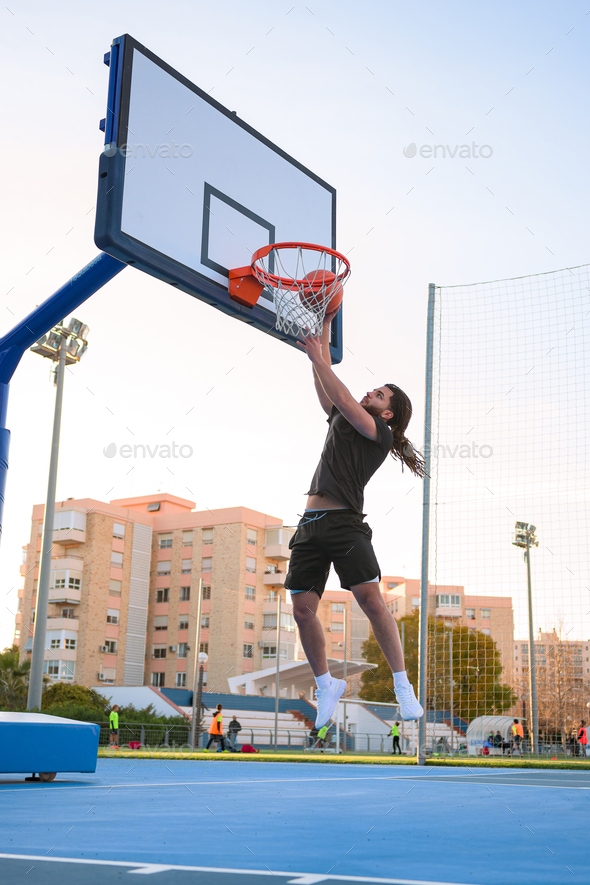 Afro-Latino man plays basketball and dunks the ball into a basket Stock ...