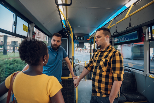 Multiracial friends talking while riding a bus in the city Stock Photo ...
