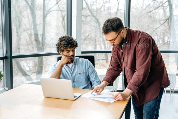 Two male business partners of different nationalities working in a ...
