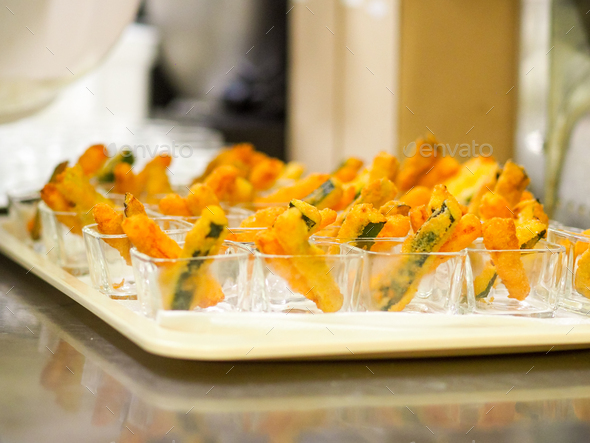 chef hand wearing gloves preparing fried snacks to serve at finger food ...