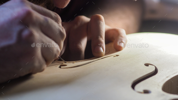 luthier violin maker working on the f holes on a raw new violin Stock ...