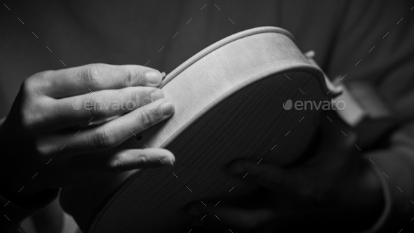 violin maker luthier hands roughing the edges of a raw blank violin ...