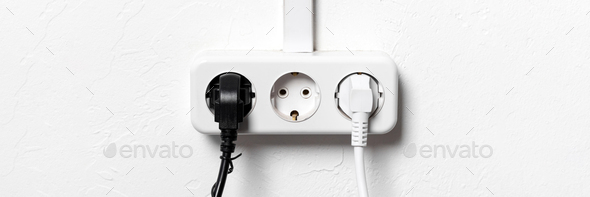 Electrical outlets with two plugs on white wall banner Stock Photo by Bykfa