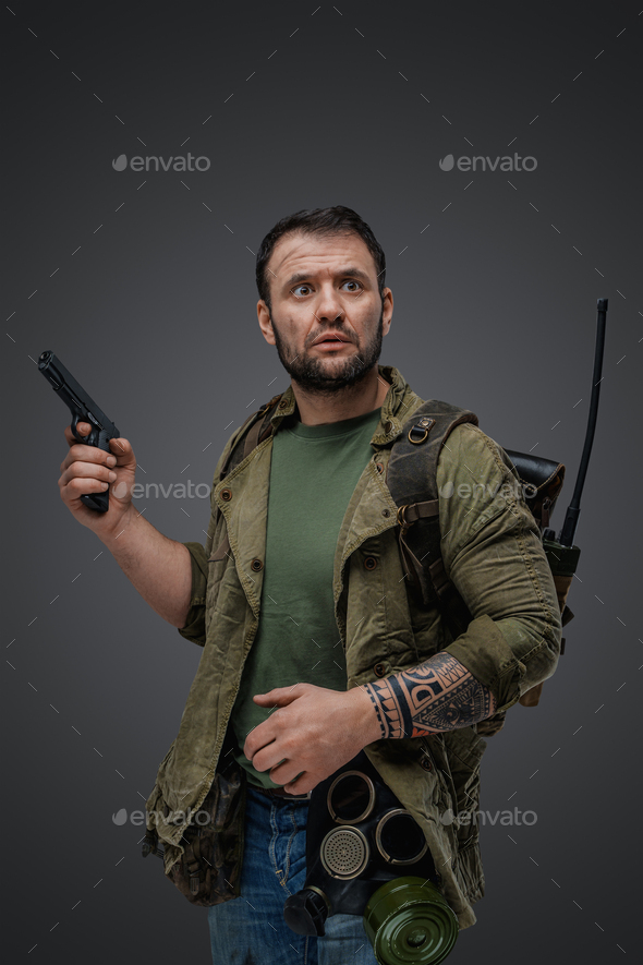 Post apocalyptic scared man with gun against gray background Stock ...