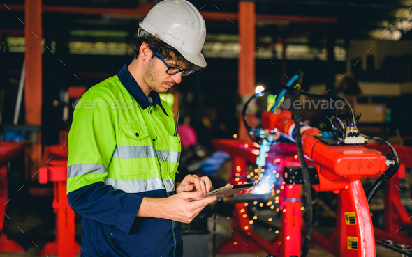 Portrait of happy male mechanical engineer in white hard hat and safety ...