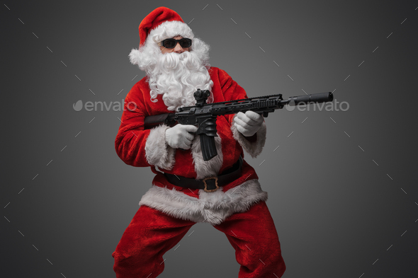 Santa gunslinger with rifle posing against grey background Stock Photo ...