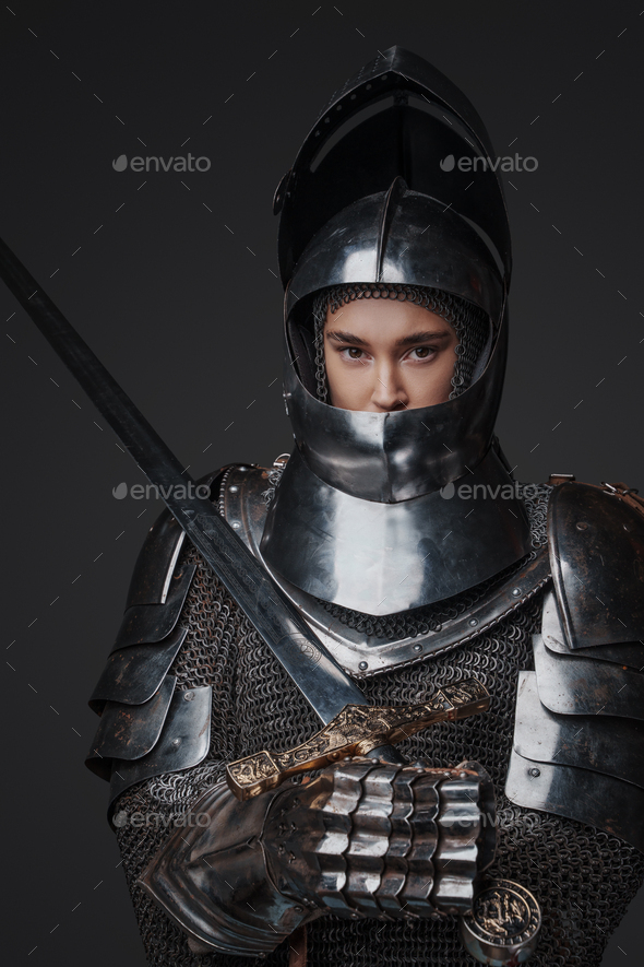 Knight woman dressed in armored clothes holding sword Stock Photo by ...