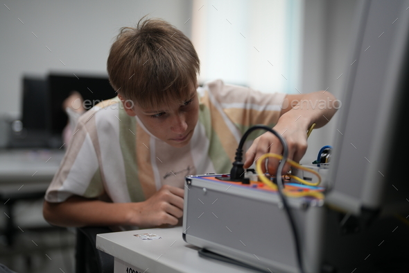 Concentrated teen child programming robot at class, stem education ...