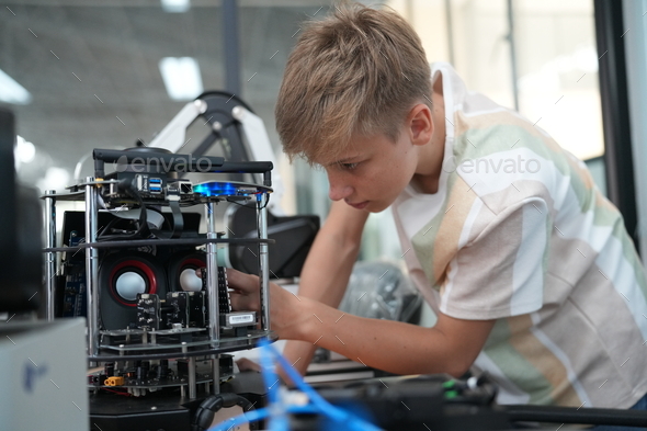 Concentrated teen child programming robot at class, stem education ...