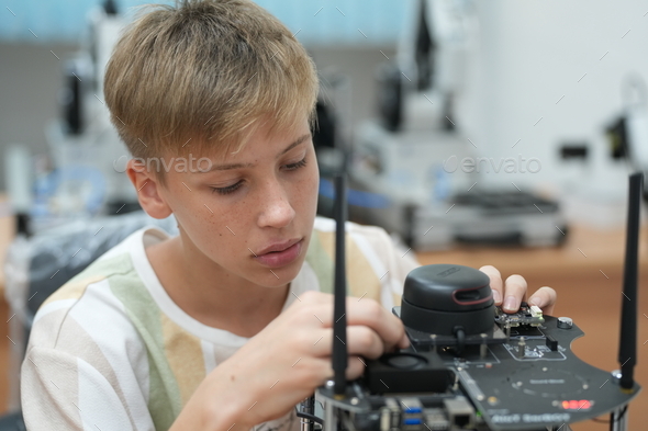 Concentrated teen child programming robot at class, stem education ...