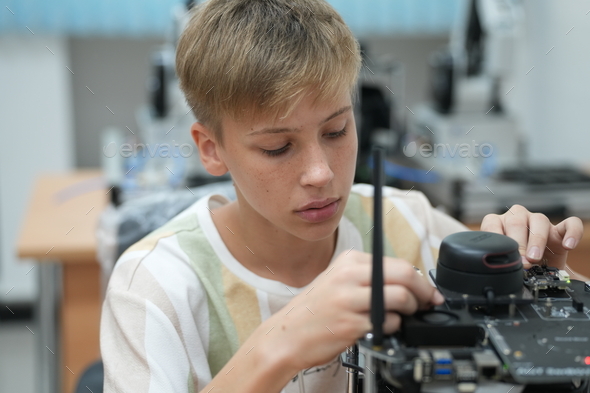 Concentrated teen child programming robot at class, stem education ...
