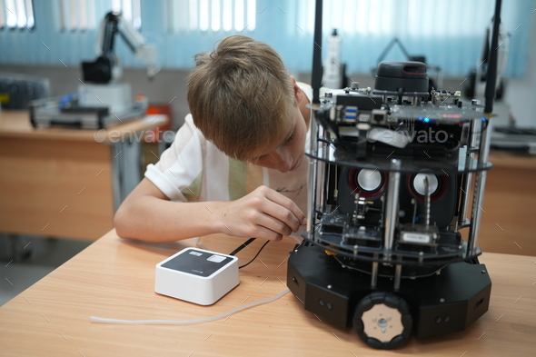Concentrated teen child programming robot at class, stem education ...