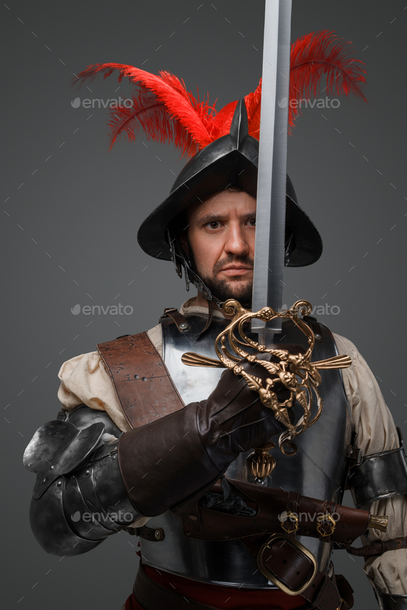 Brave musketeer with epee dressed in plate armor and helmet Stock Photo ...