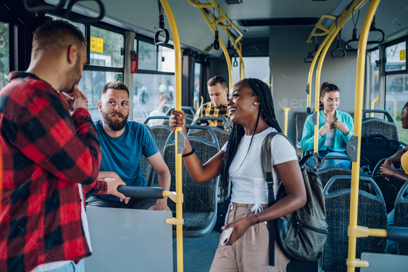 Multiracial friends talking while riding a bus in the city Stock Photo ...