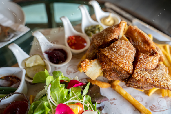 Eisbein with braised cabbage, salad and Yummy french fries with set of ...