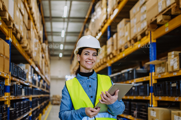 Warehouse female worker checking up stuff in a warehouse. Stock Photo ...