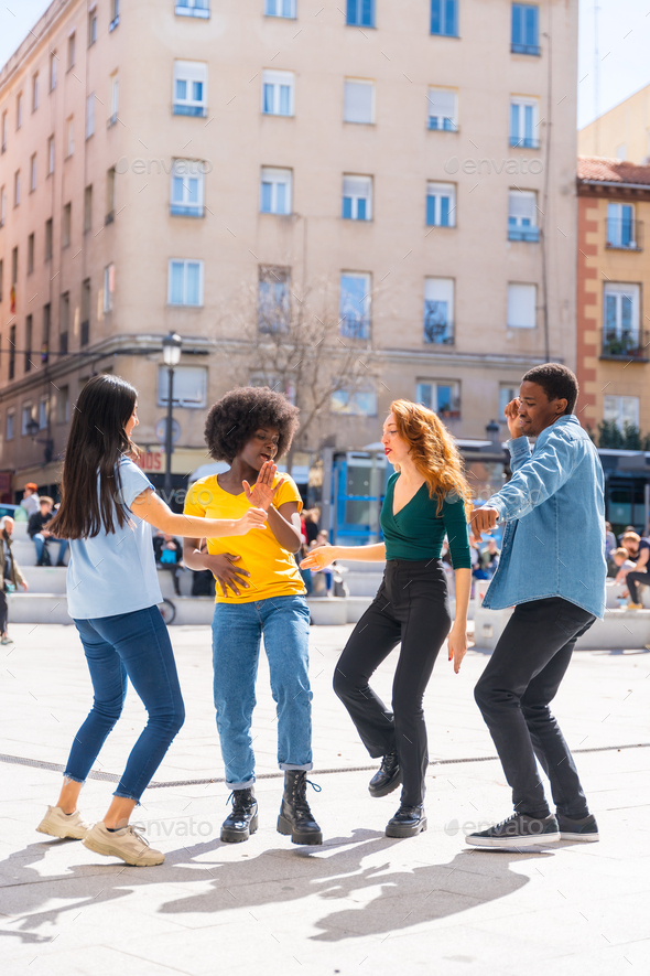 Multi-ethnic young friends dancing in a city square, group dancers ...