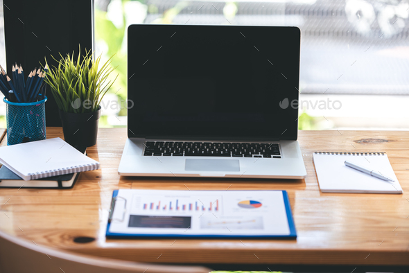 Modern office with blank screen laptop and office equipment on the desk ...