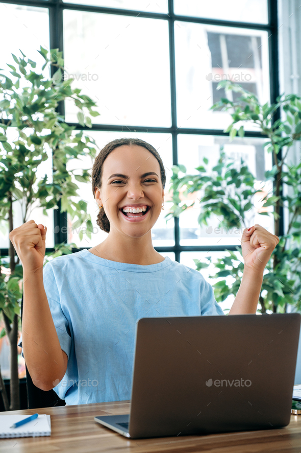 Vertical photo of excited happy mixed race young business woman, sit at ...