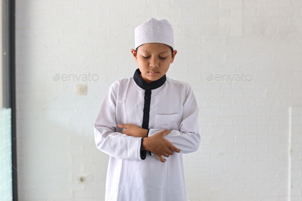 Muslim kid praying salah on prayer mat Stock Photo by Queenmoonlite35
