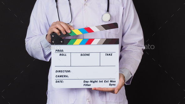 Doctor hand is holding stethoscope and clapper board on black ...