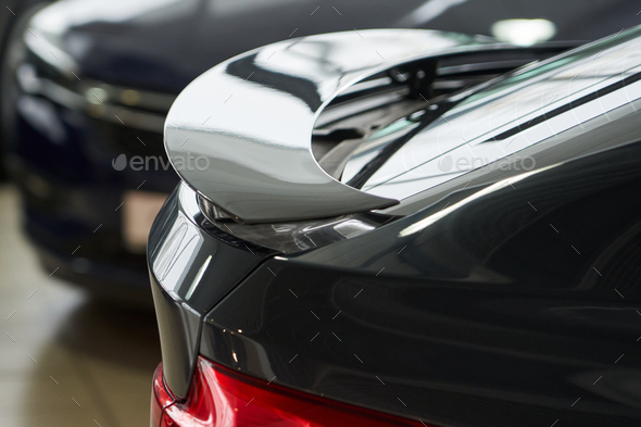 top on the rear wing a quick view of a high-speed dark-colored car in a ...