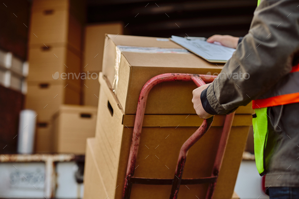 Close up of courier loading packages for delivery into a van, Stock ...