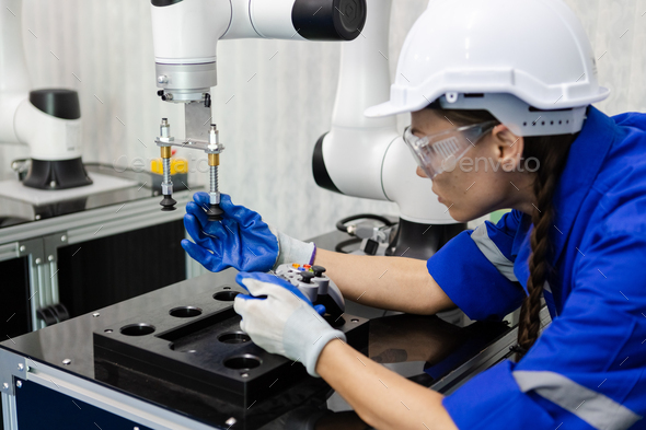 Close up robot arm, female technician engineer using remote control ...