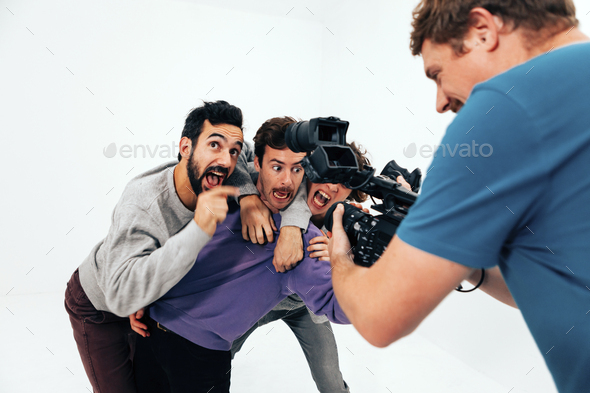 three people acting in front of the camera in a white studio background ...